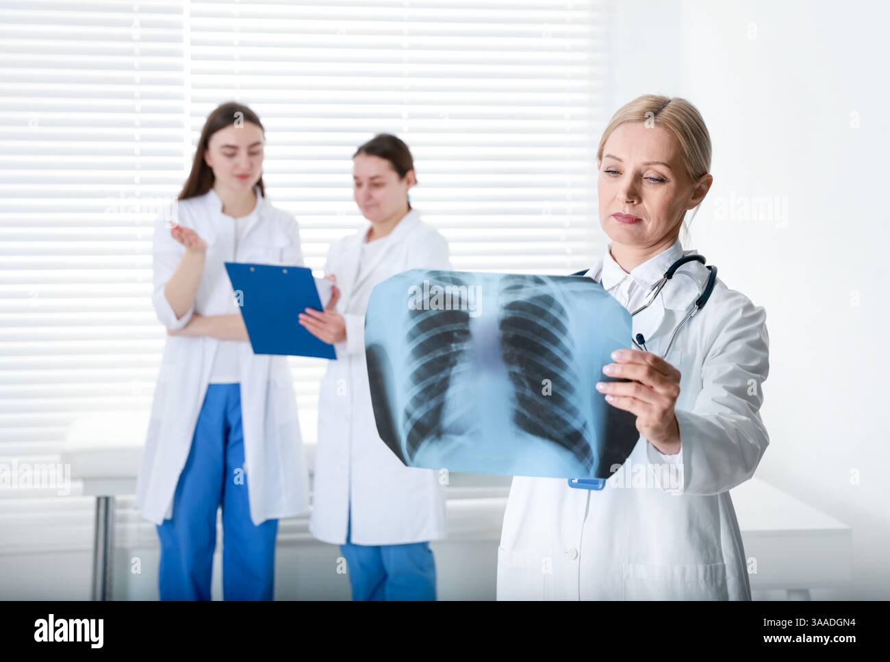 Doctor examining chest x-ray in clinic. Medical assistants with ...