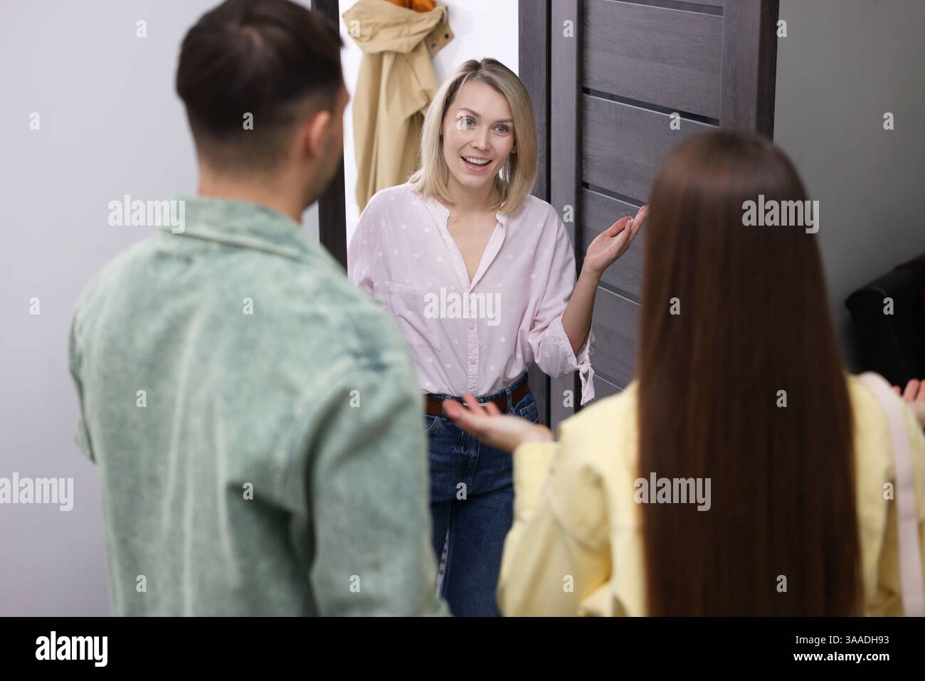 Cheerful woman welcoming neighbors hi-res stock photography and images ...