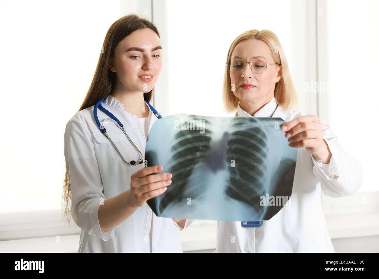 Doctors examining chest x-ray near window in clinic Stock Photo - Alamy