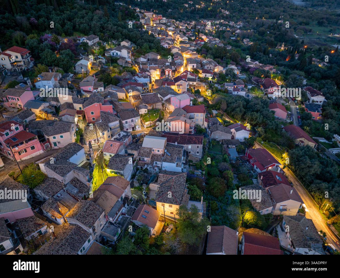 Aerial view of a European village at dusk, with glowing street lights ...