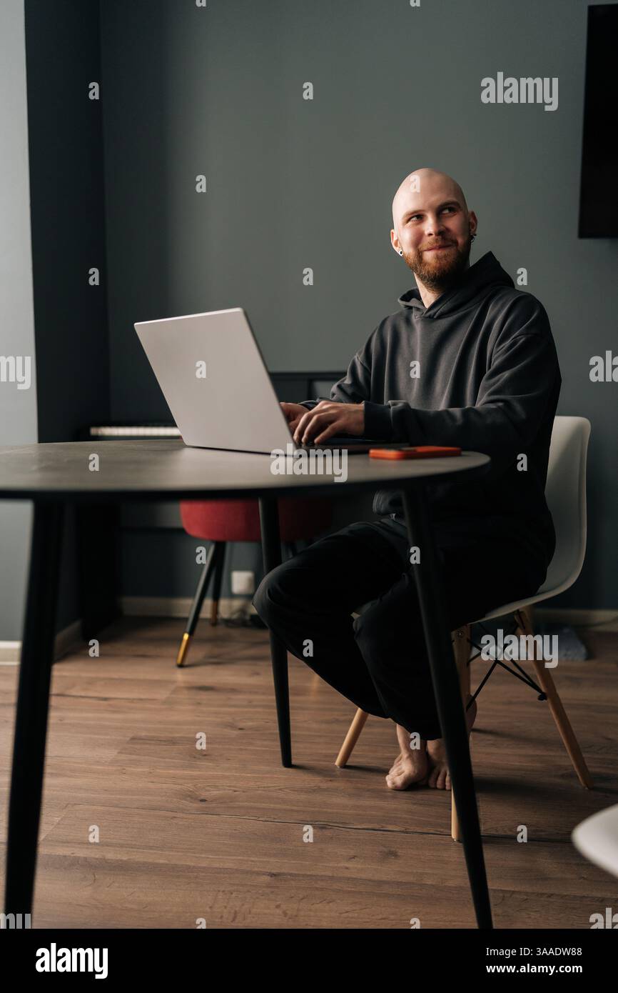 Full length vertical portrait of cheerful programmer male remote working from home office ...