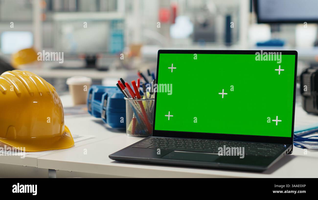Chroma key laptop in photovoltaics factory used to monitor system performance. Green screen ...