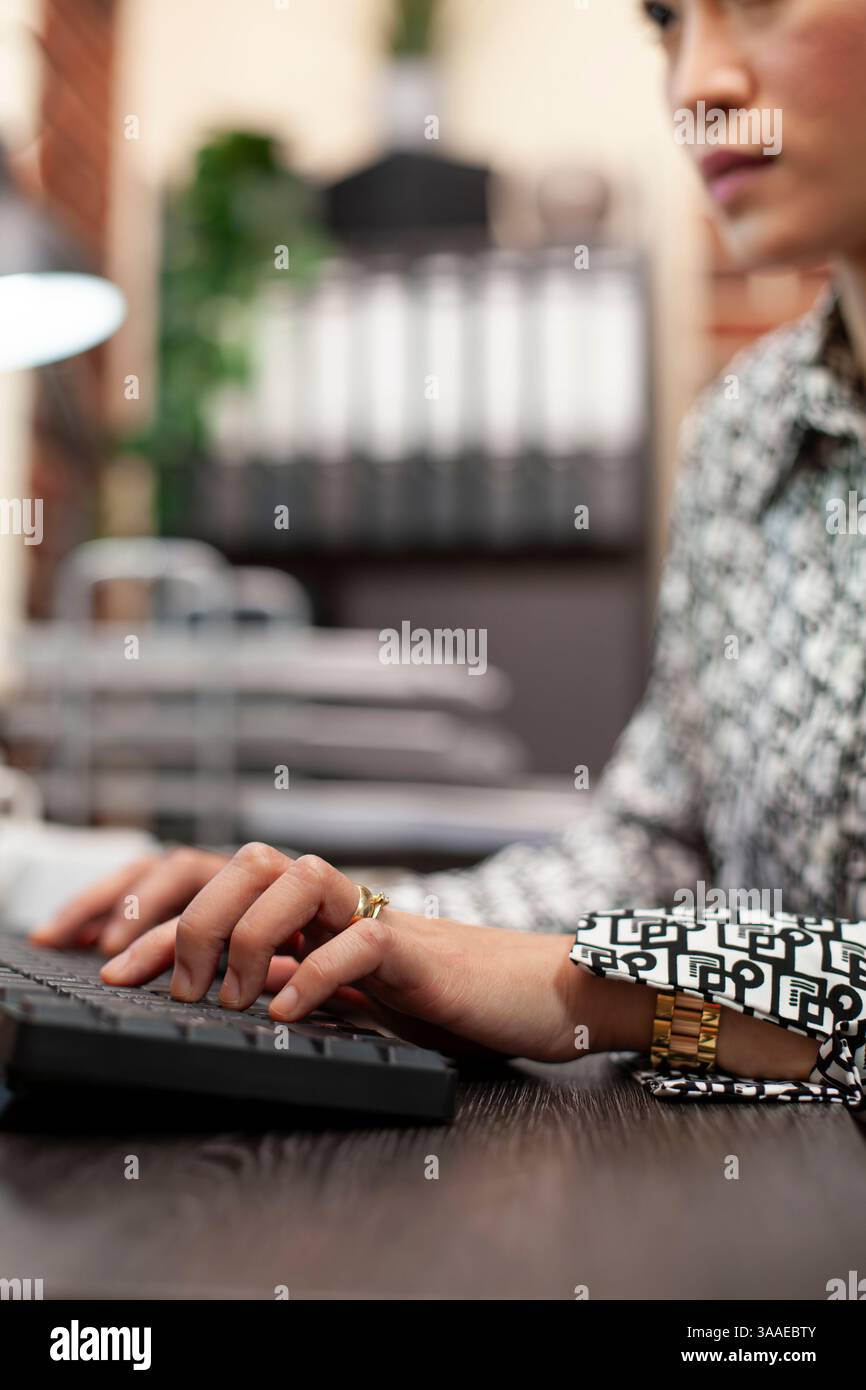 Female professional typing on computer keyboard at a modern office desk ...