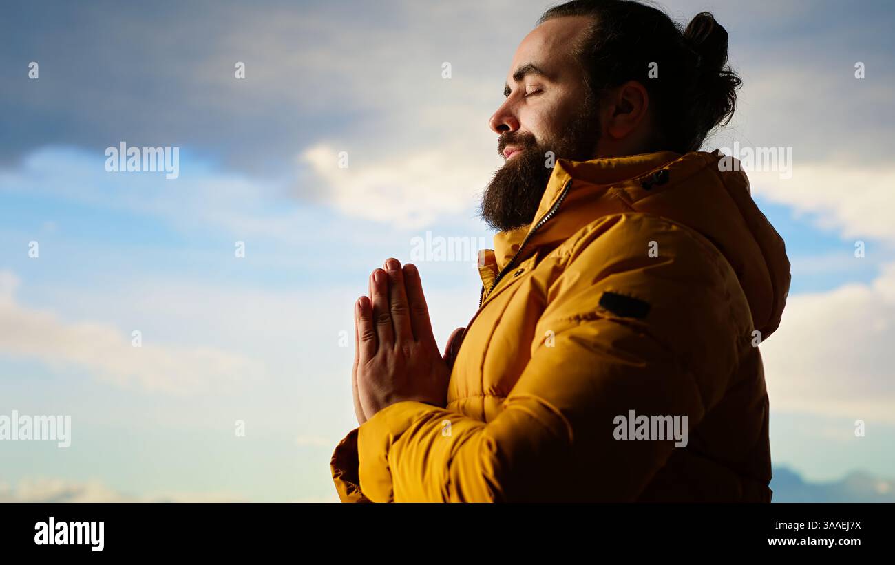 Adventure seeker doing a meditation pose on top of the mountain ...