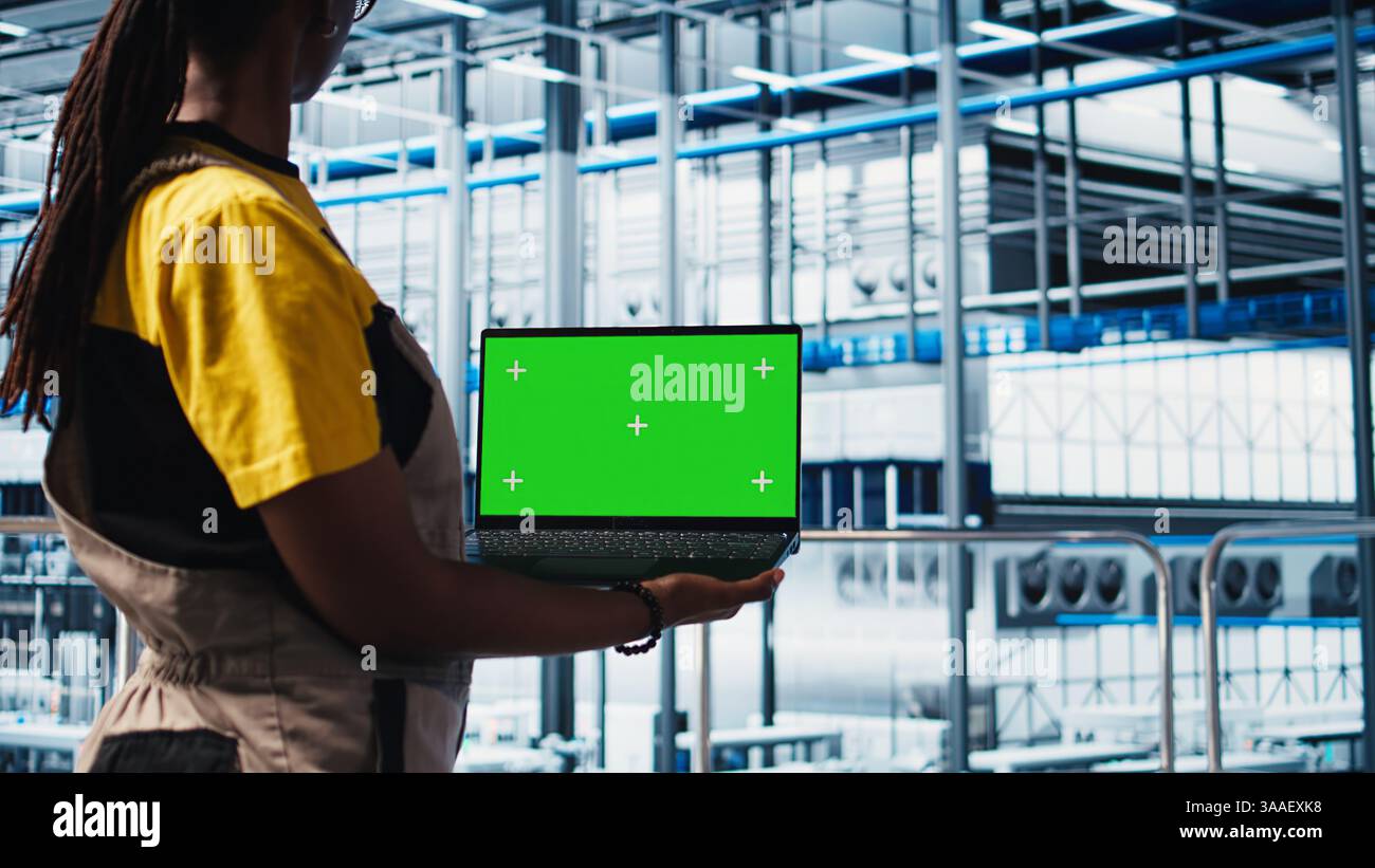 Smart factory professional implements automated workflows using isolated screen laptop ...