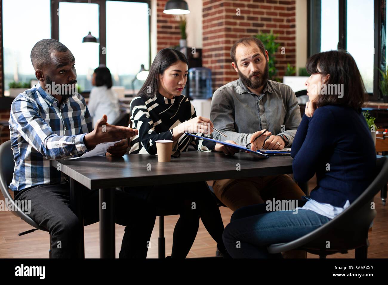 Multiethnic HR team seated at table with cv resumes, evaluating and ...