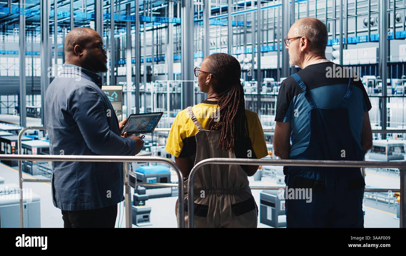 Manager supervising photovoltaic smart factory workers designing production lines in CAD ...