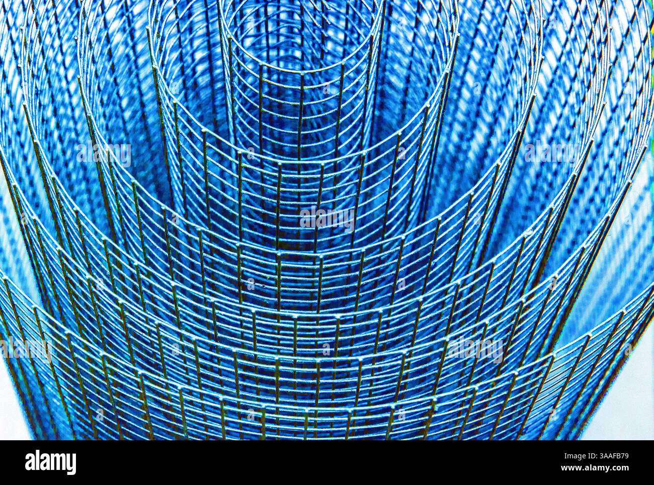 Abstract spiral metal coiled wire mesh with blue grid pattern ...