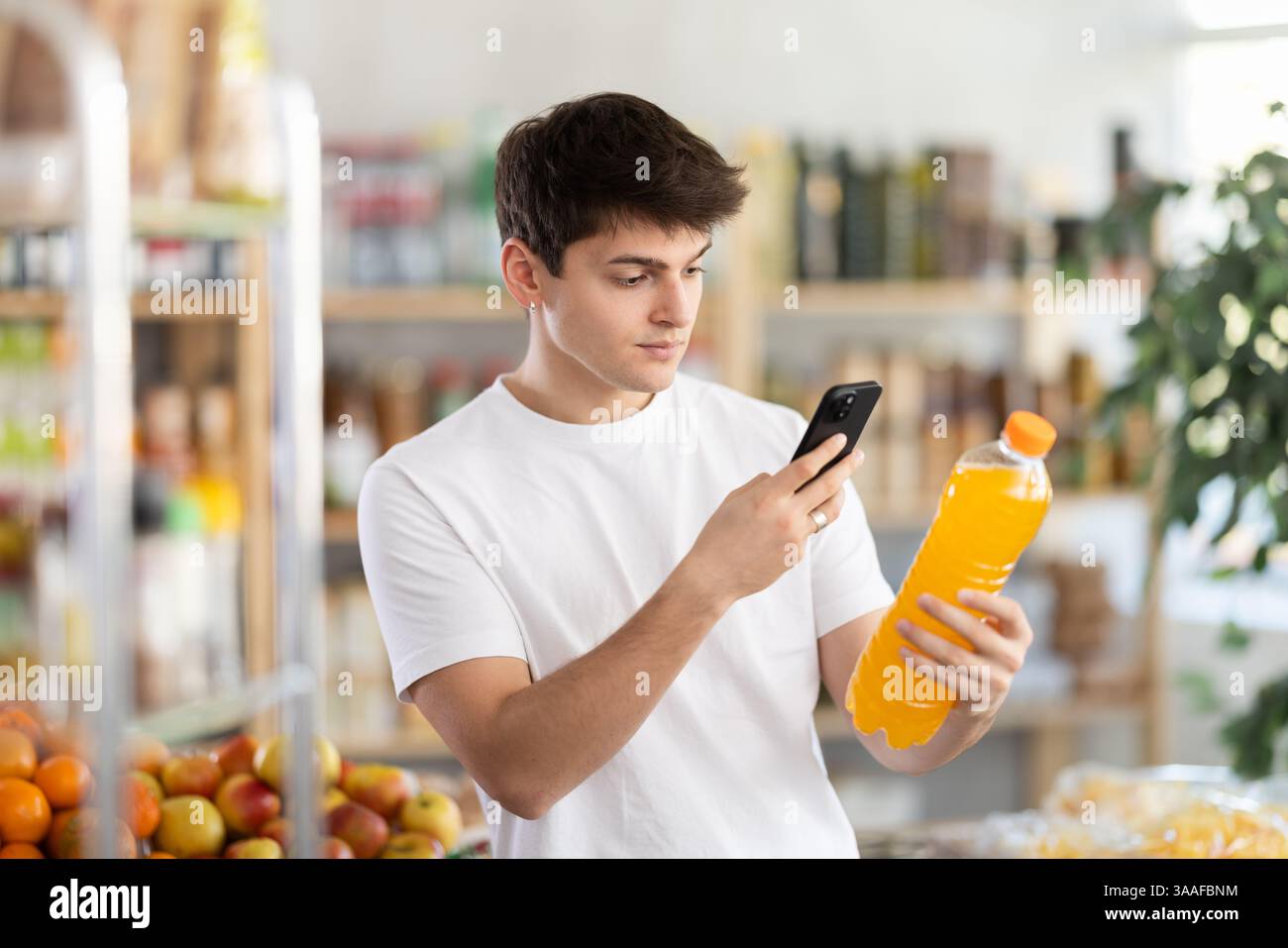 Guy scanning QR code on soft drink bottle in supermarket Stock Photo ...