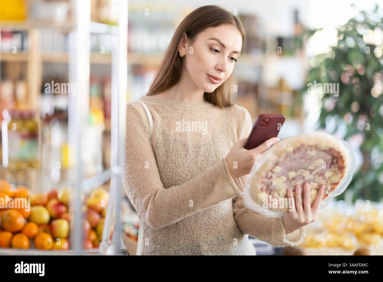 In shop girl scans QR code and take reading on pizza with prosciutto ...