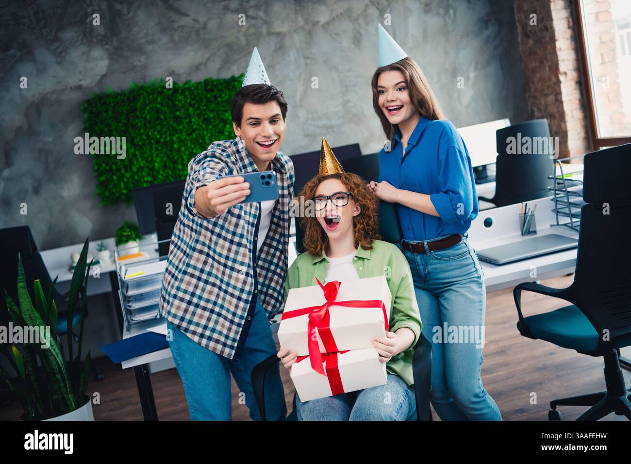 Young happy colleagues celebrating a birthday together in the office ...