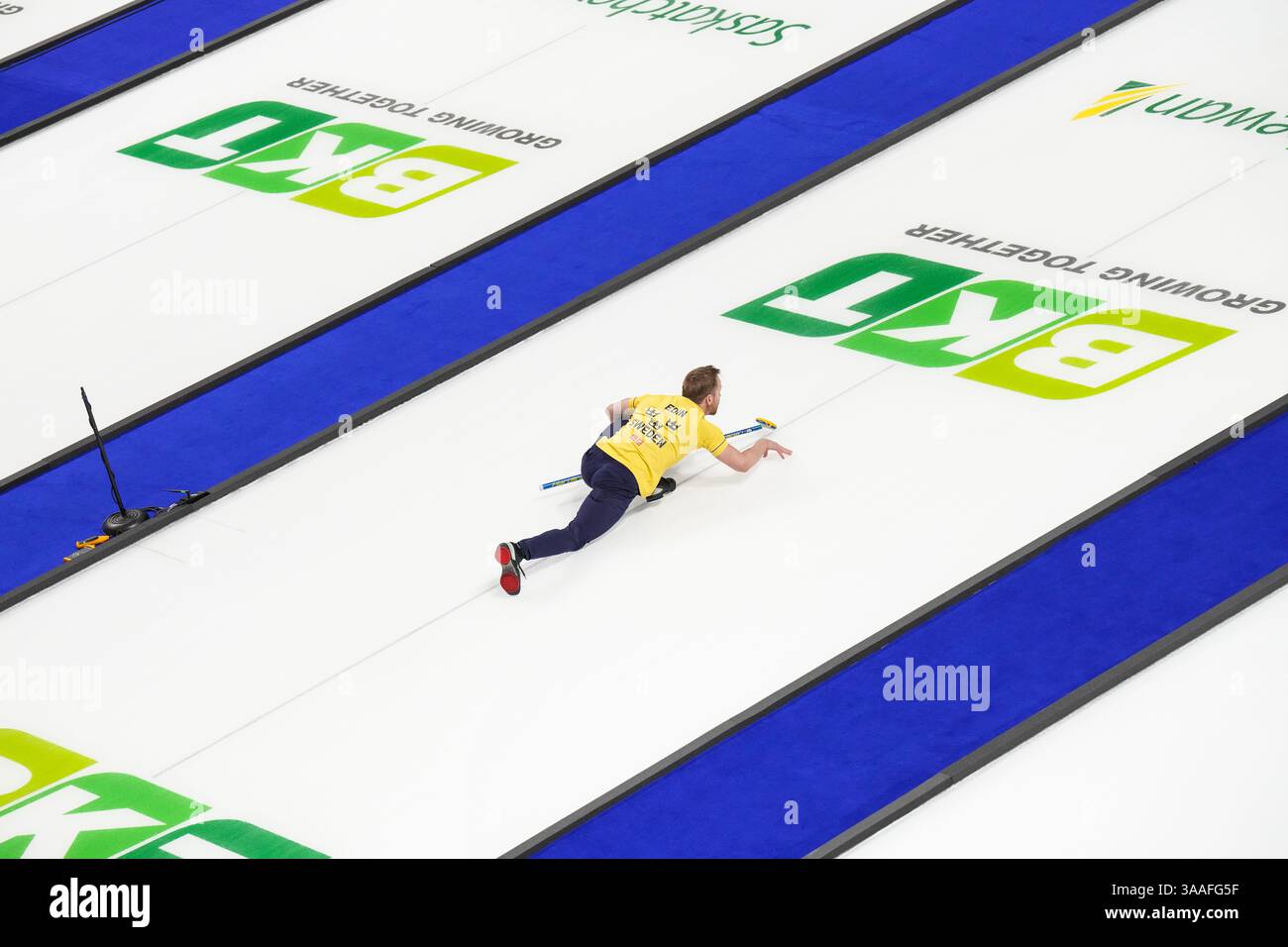 Sweden's skip Niklas Edin throws a stone as Rasmus Wrana and ...