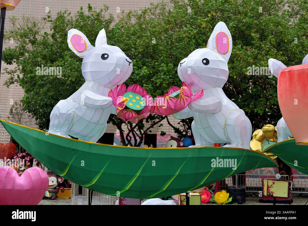 Twin white papercraft rabbits holding lotus root to celebrate Chinese ...