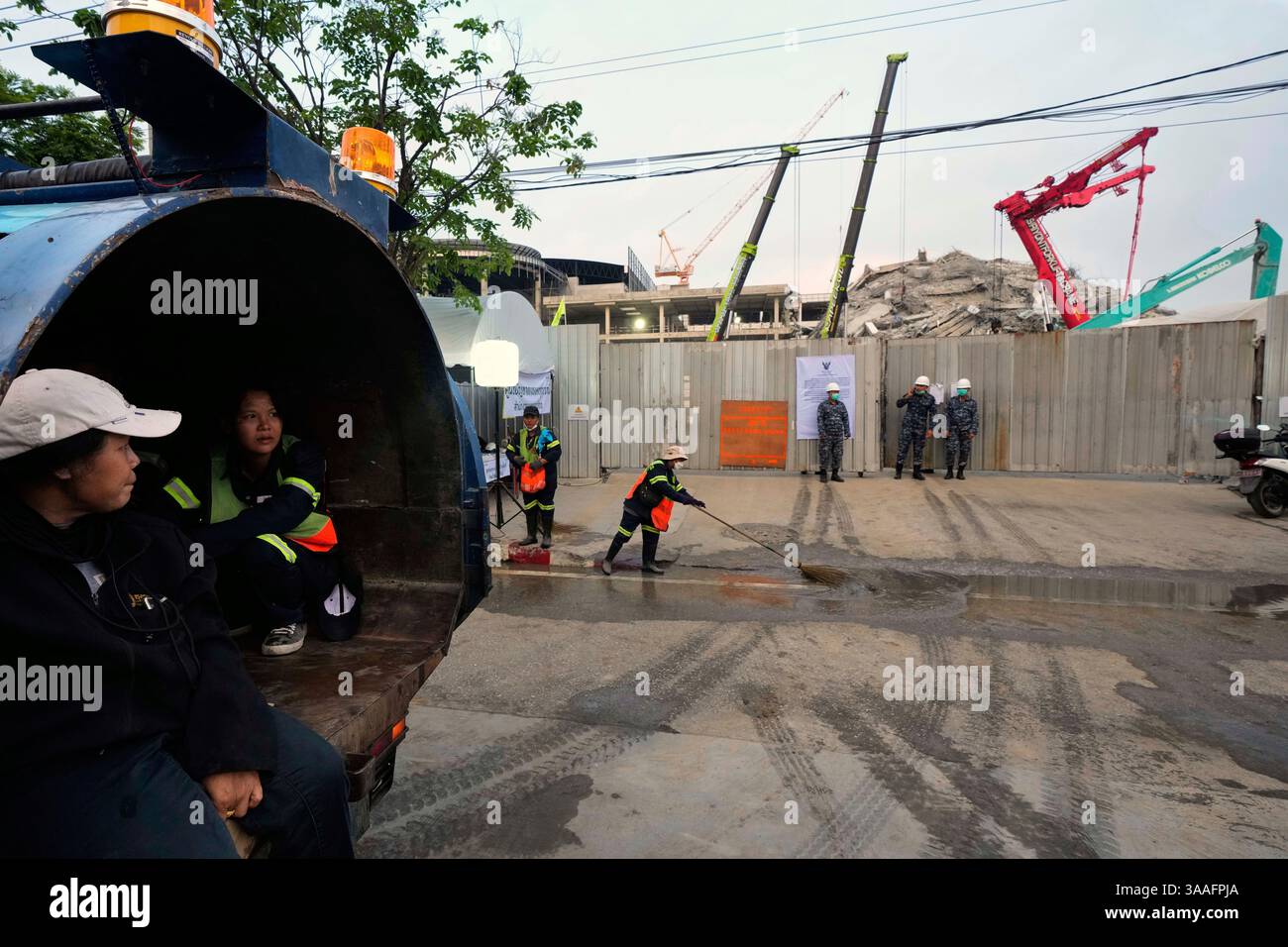 Volunteers sit back in a vehicle as they drive past the site of an ...