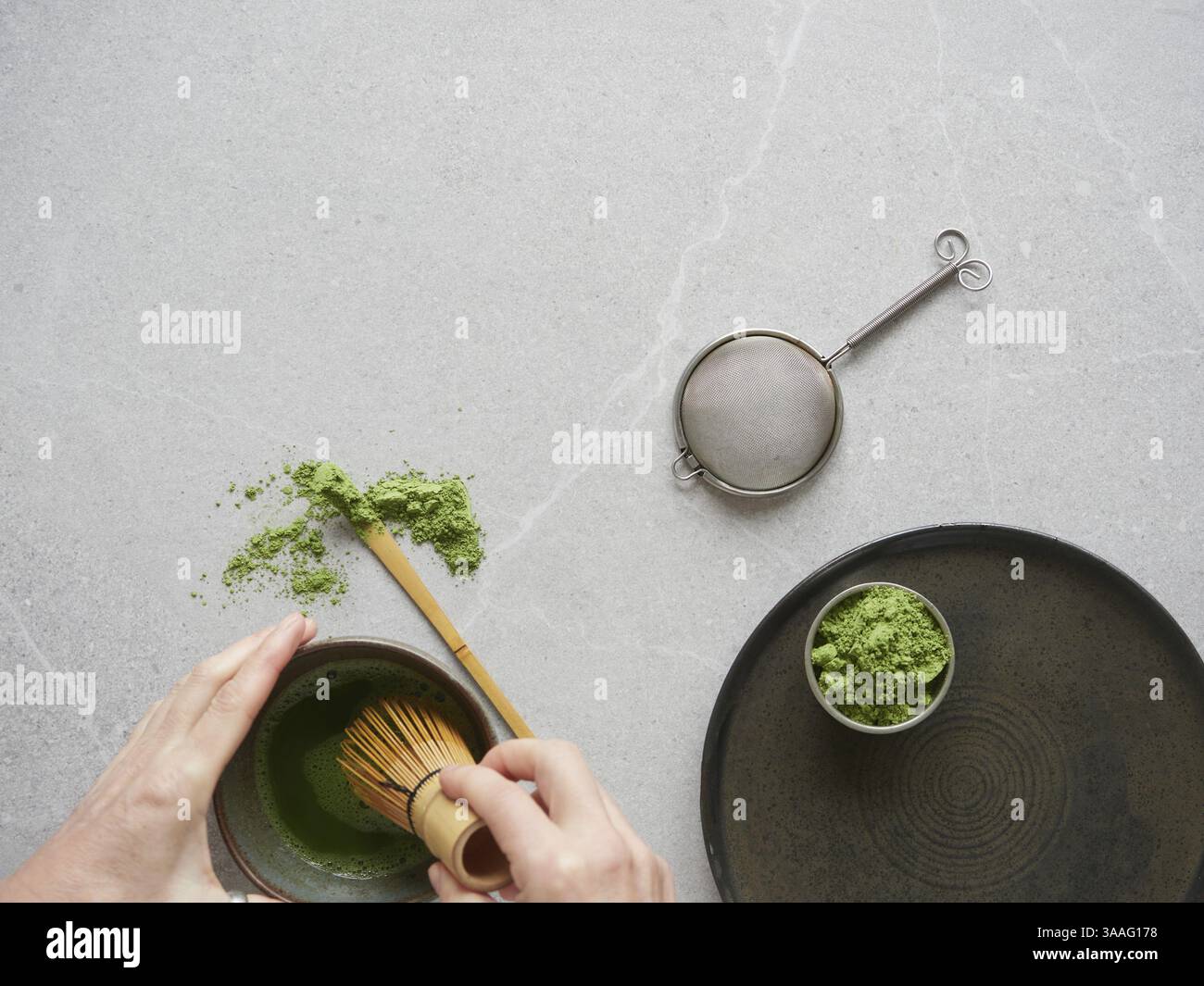 Preparation of green tea drink with matcha powder. Hands with ...
