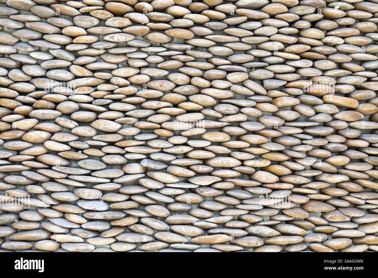 Stone wall, lined with small pebbles Stock Photo - Alamy