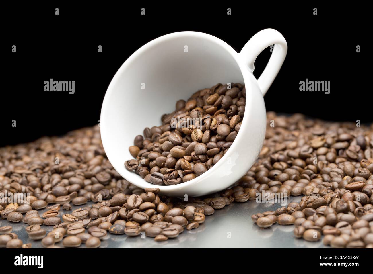 Coffee beans spilled out of coffee cup. On black background Stock Photo ...