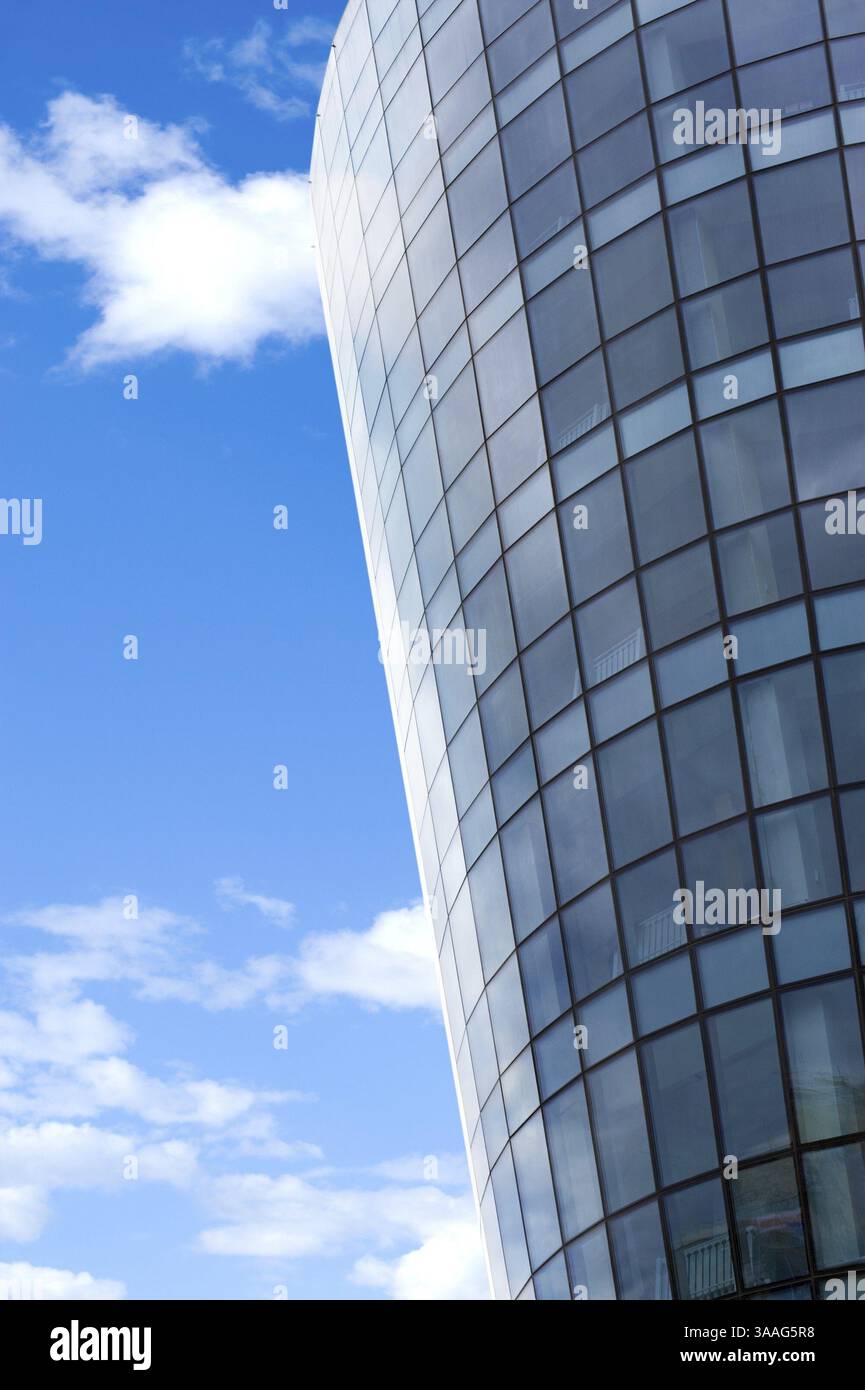 A half round glass multistory building widened upwards Stock Photo - Alamy