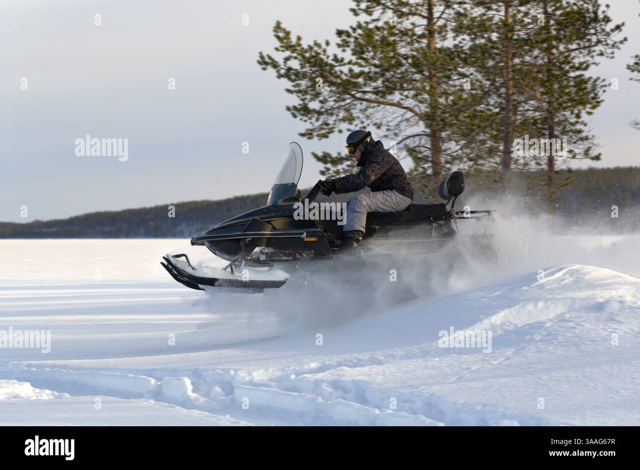 Man riding a snowmobile on the lake Stock Photo - Alamy