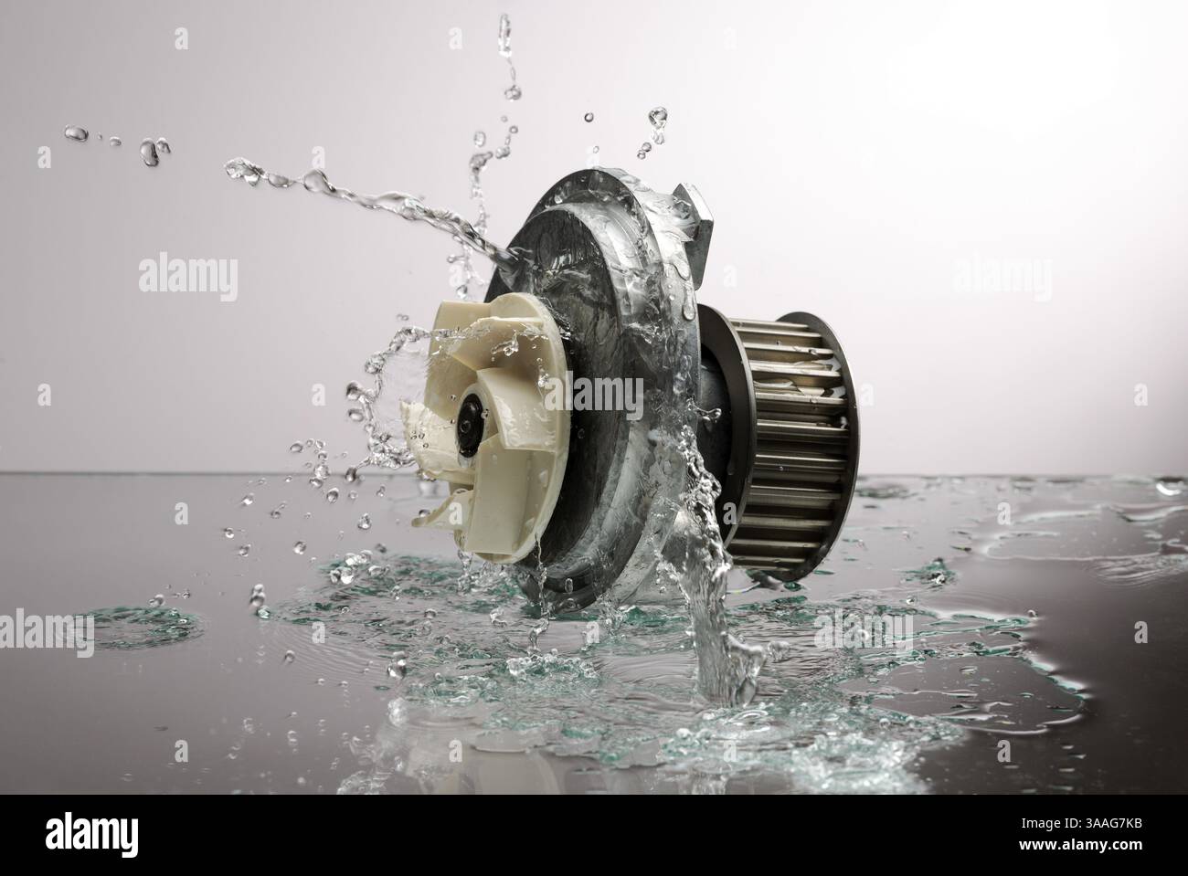 Auto parts, engine cooling pump in spurts of water on a light gradient ...