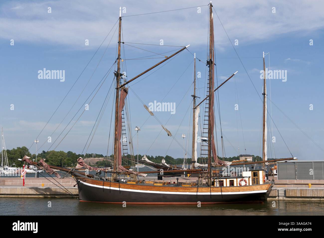 Wooden sailing vessel in the port with a flat sail Stock Photo - Alamy