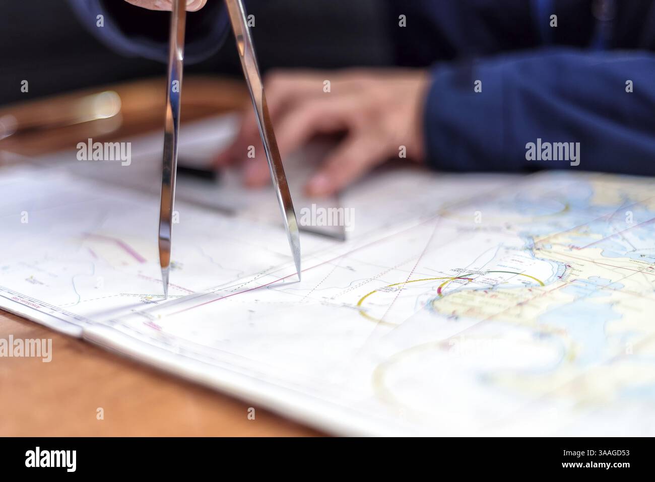Navigation with nautical charts in the chart room on a sailing yacht ...