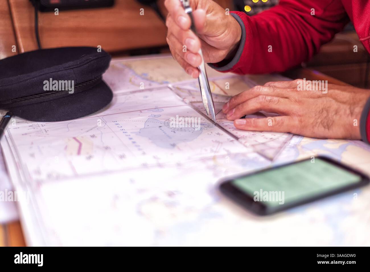 Navigation with nautical charts in the chart room on a sailing yacht ...