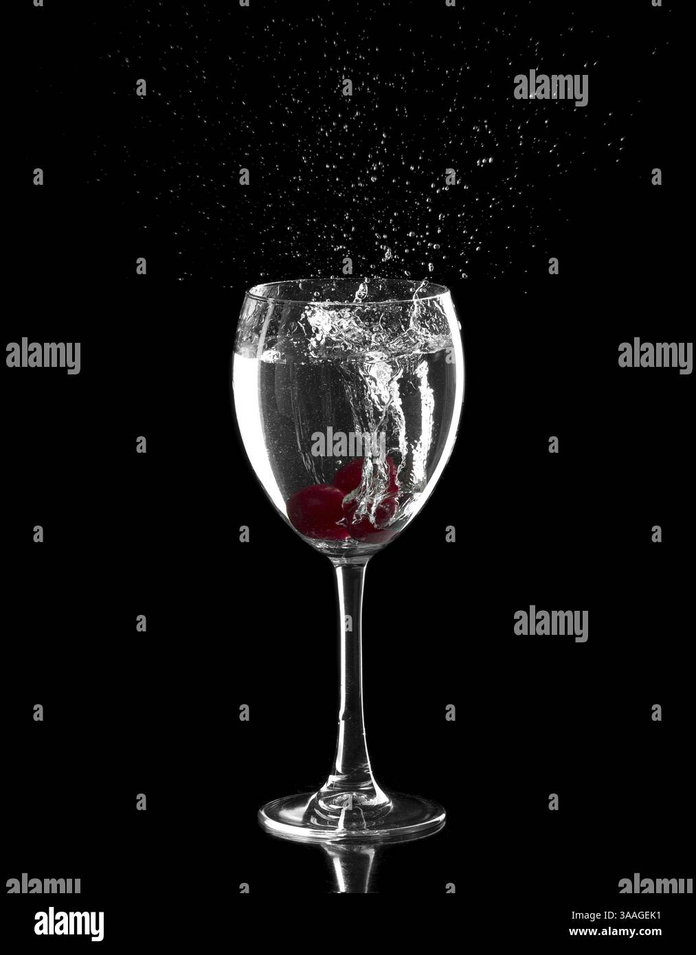 Cocktail splash, with red cherries splashing in to a cocktail glass ...