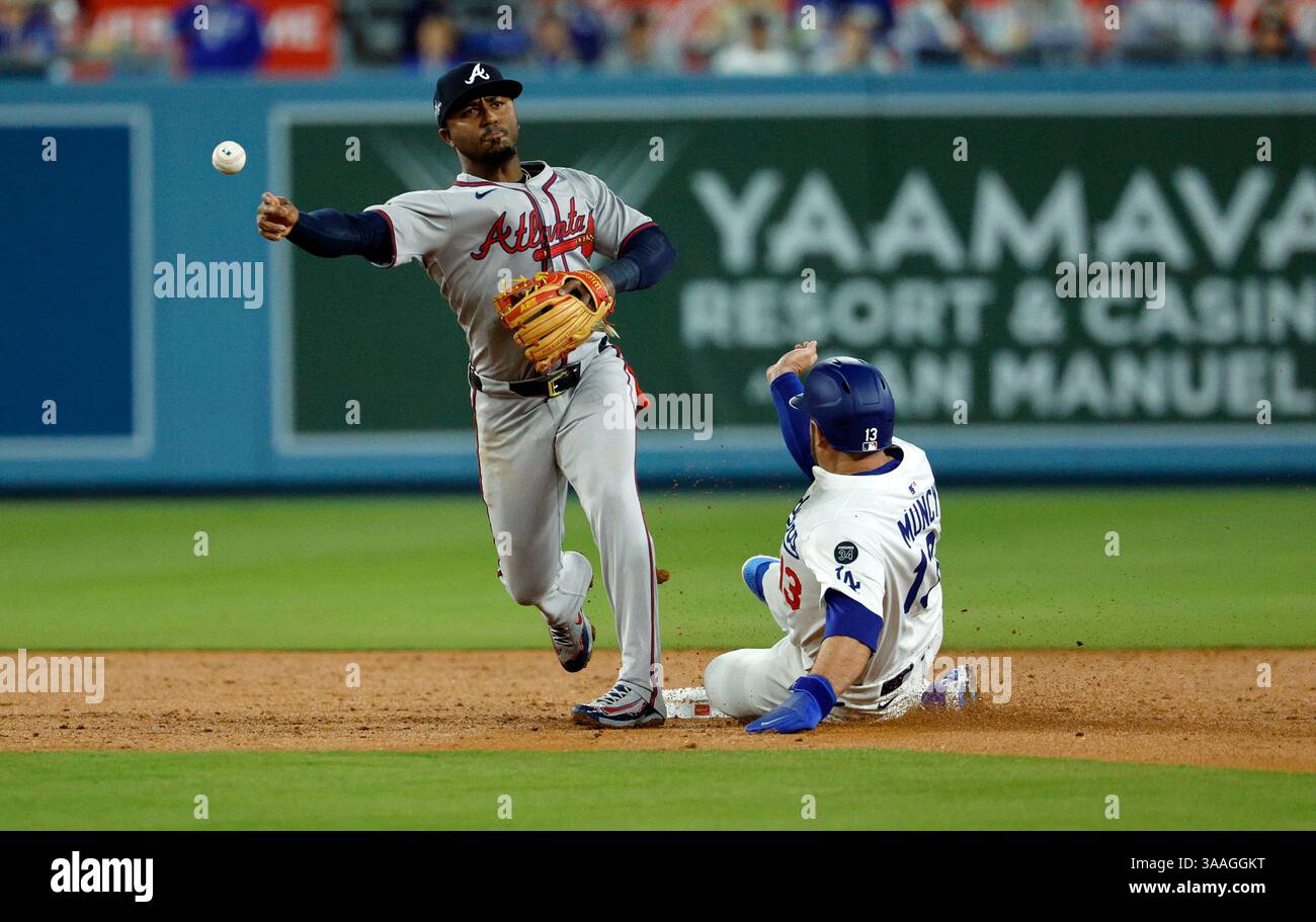 Atlanta Braves' Ozzie Albies, left, turns a double play at second base ...