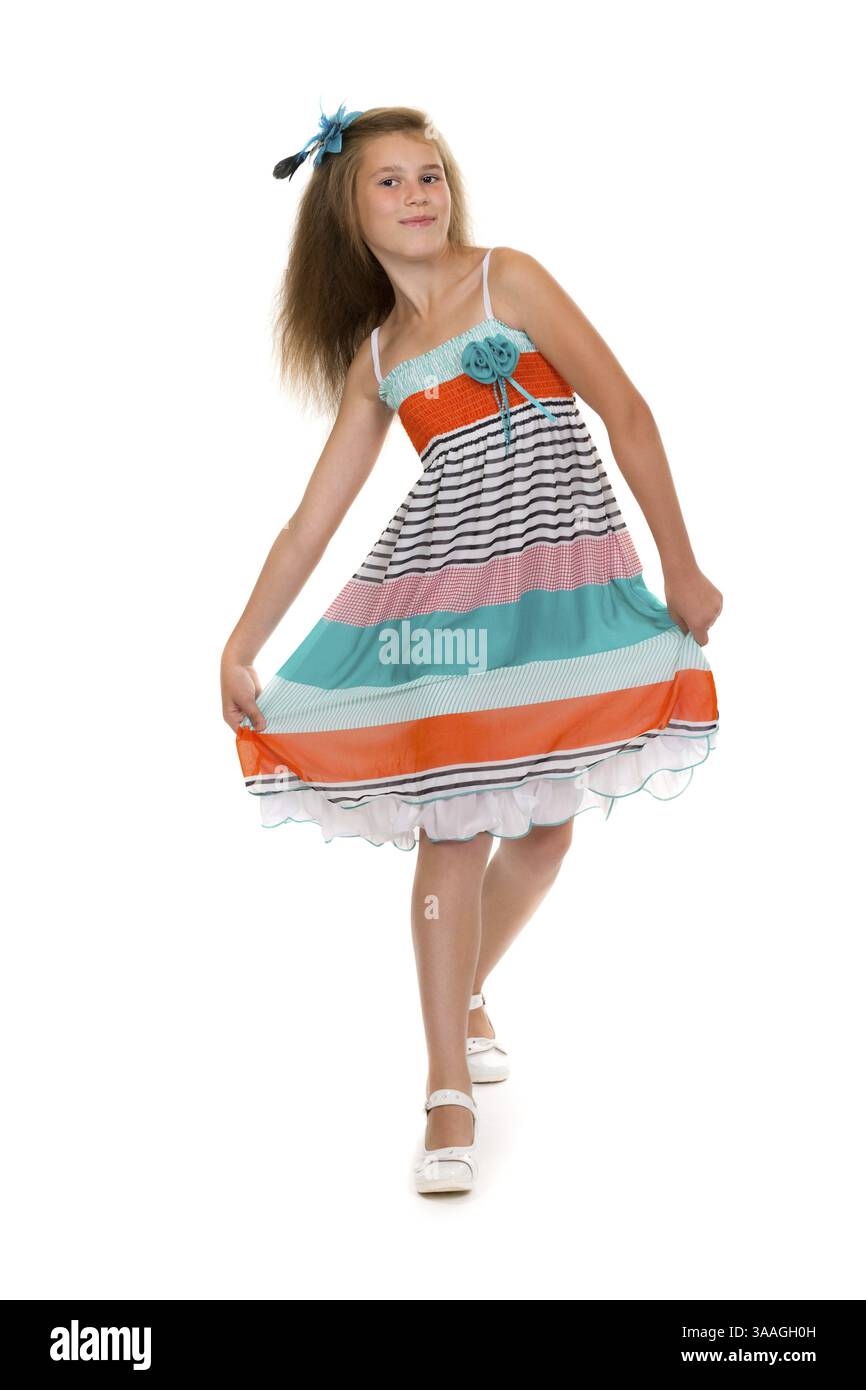 11 year old girl dances in colorful dress in the studio. Isolate on ...