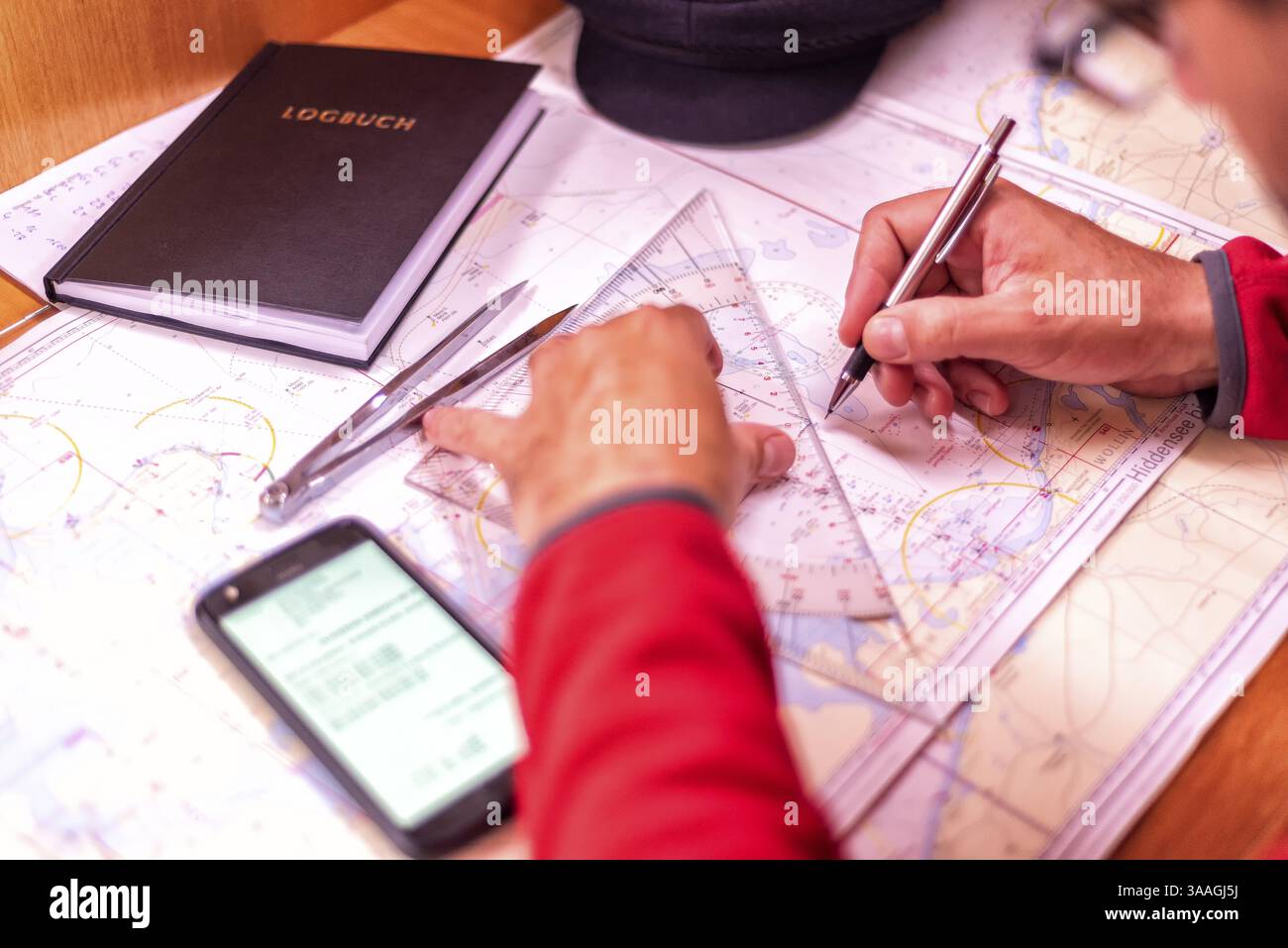 Navigation with nautical charts in the chart room on a sailing yacht ...