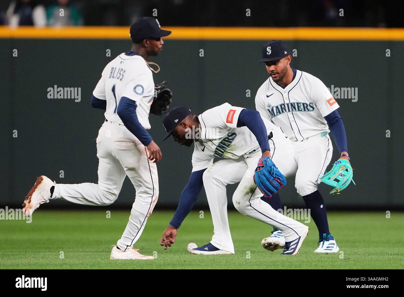 Seattle Mariners second baseman Ryan Bliss, left, looks on as he, right ...