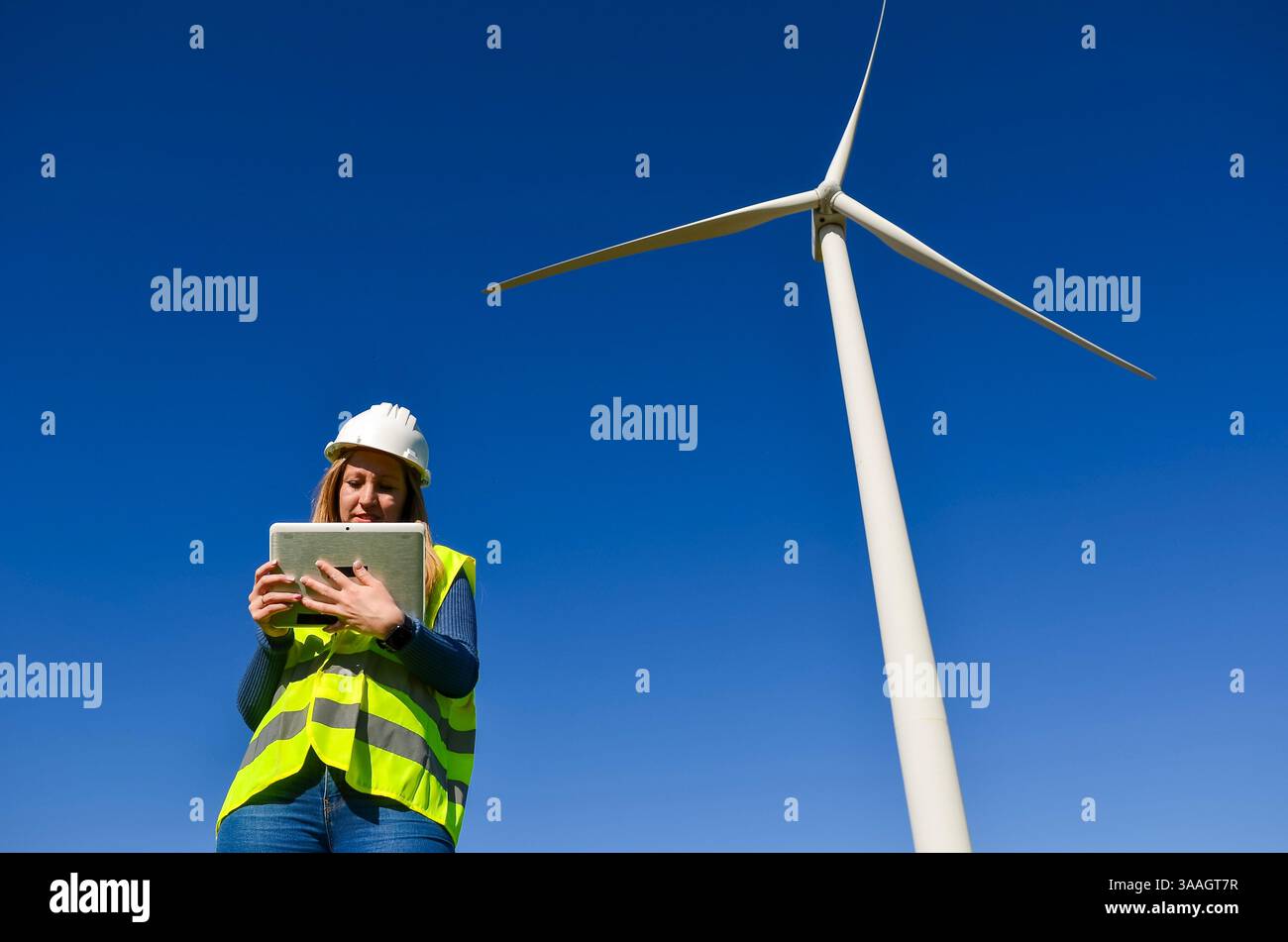 Female engineer using tablet working in a wind turbine power station ...