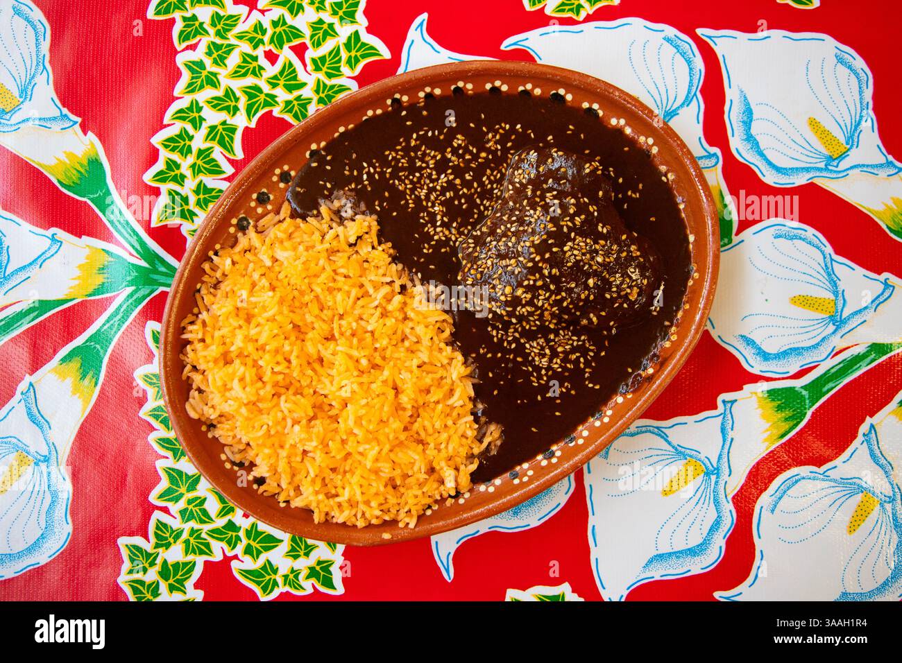 A traditional clay pottery dish with mole and chicken from Puebla, a ...