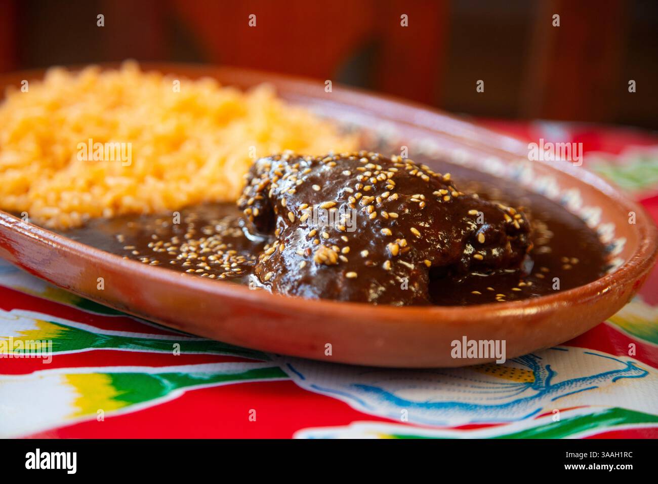 A traditional clay pottery dish with mole and chicken from Puebla, a ...
