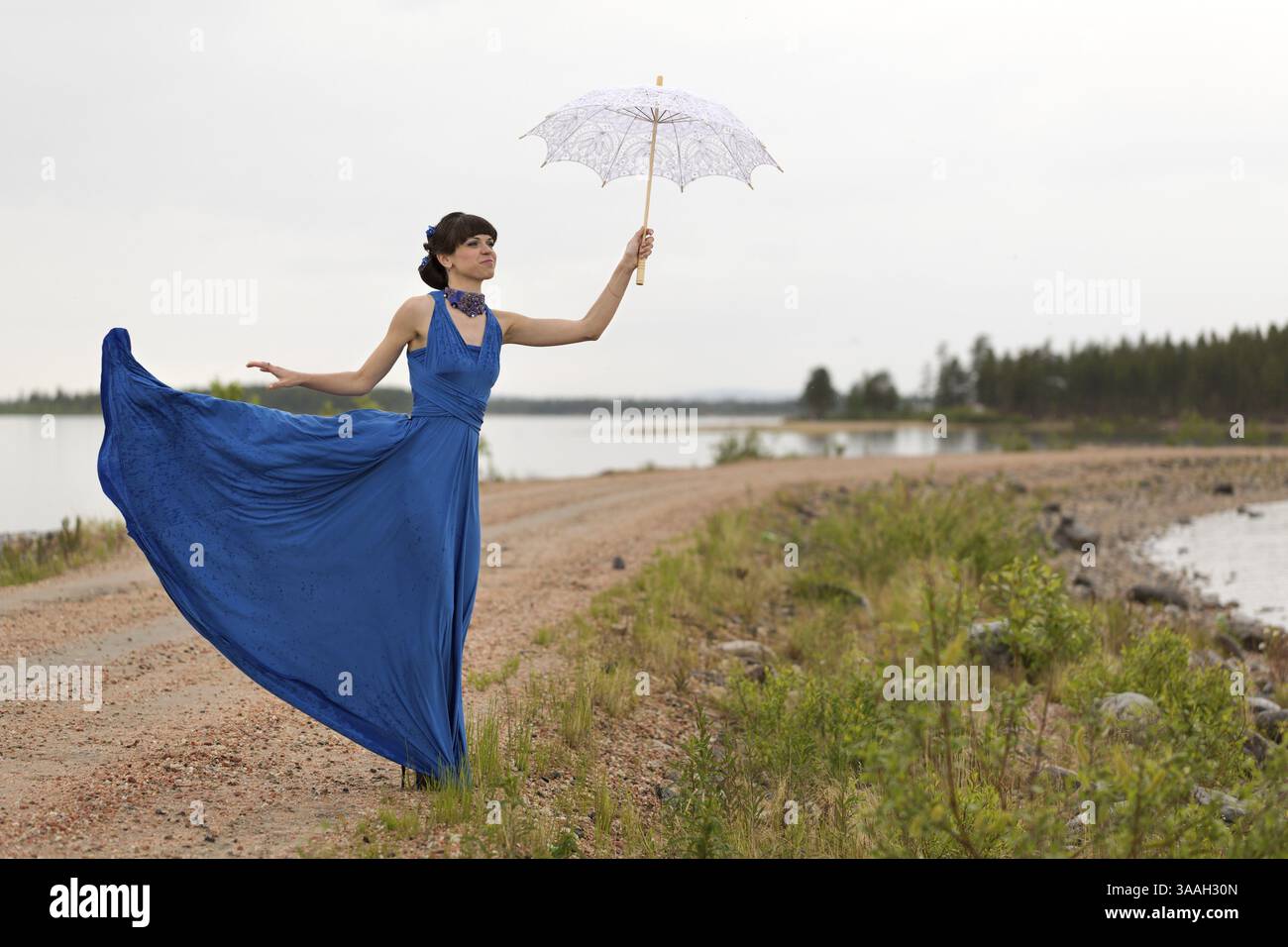 Girl tries to keep a umbrella which pulls out a wind from her hands ...