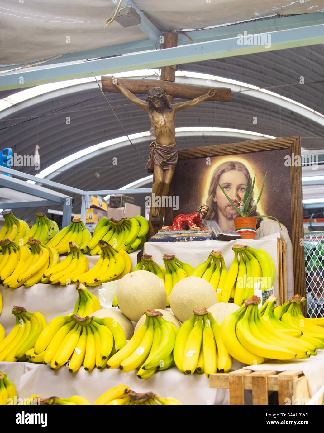 A fruit stand with bananas and a religious photo in a market in the ...