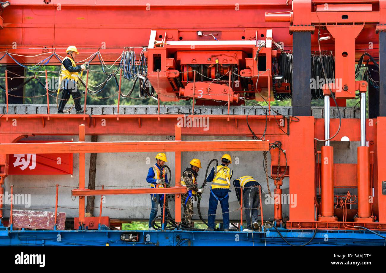 Fuquan. 31st Mar, 2025. Workers install a T-beam at the construction ...