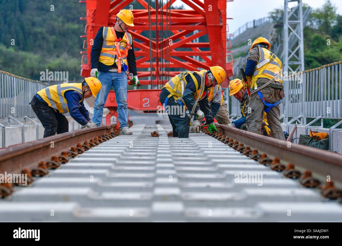 Fuquan. 31st Mar, 2025. Workers lay tracks at the construction site of ...