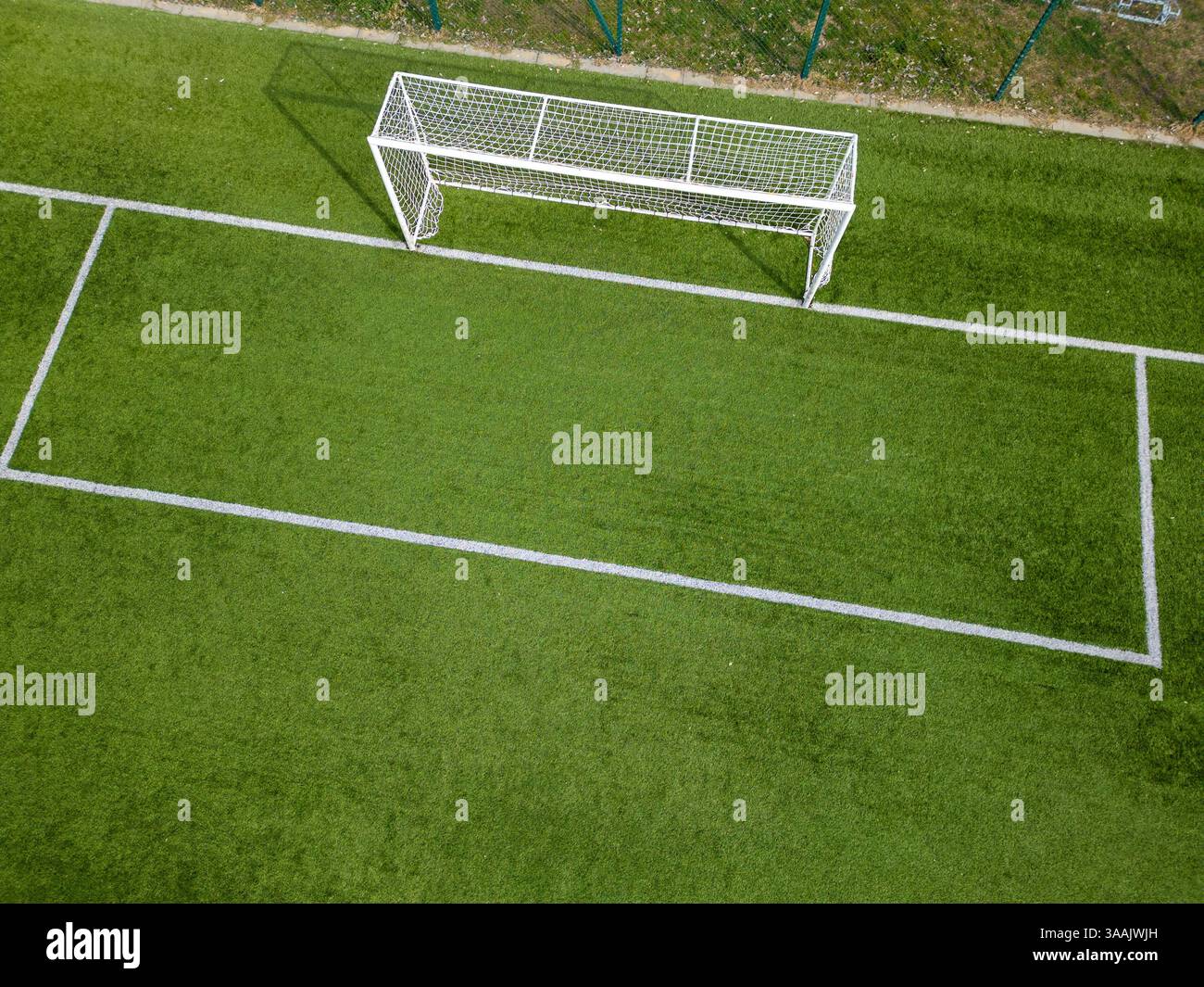 Aerial view of a soccer goal on a green artificial turf field with ...