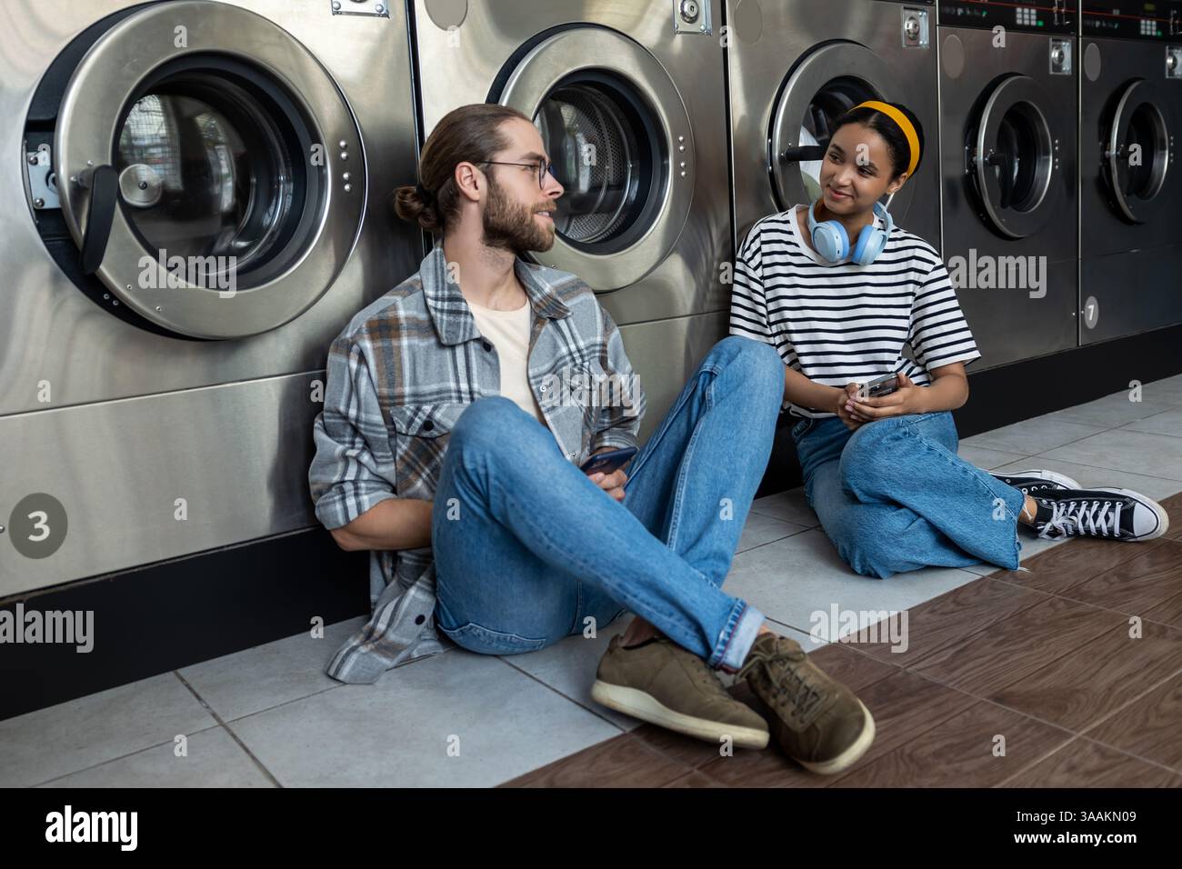 Man and woman communicating and completing their routine washing chore ...