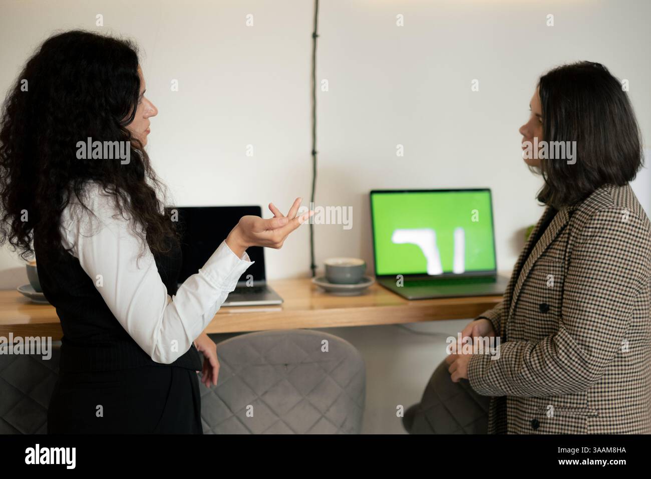 Business conversation between two women at coworking Stock Photo - Alamy
