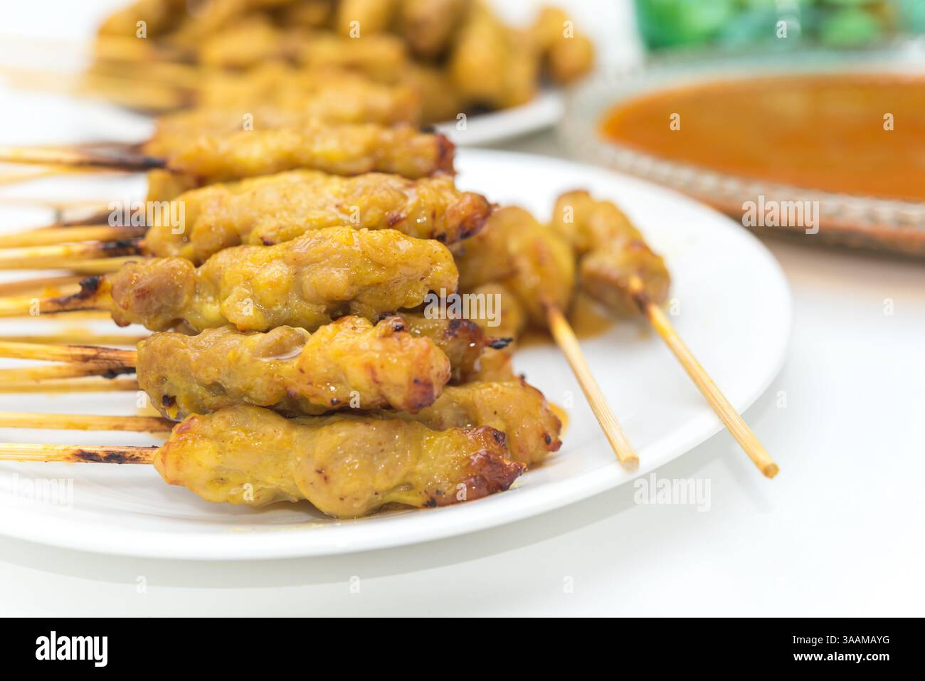 Pork satay with peanut sauce served with pickles which are cucumber ...