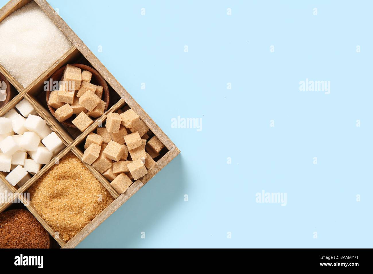 Wooden box with different types of sugar on blue background Stock Photo ...
