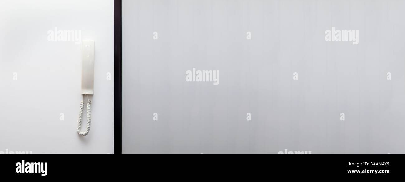 A modern intercom system with a white telephone receiver, displayed on ...