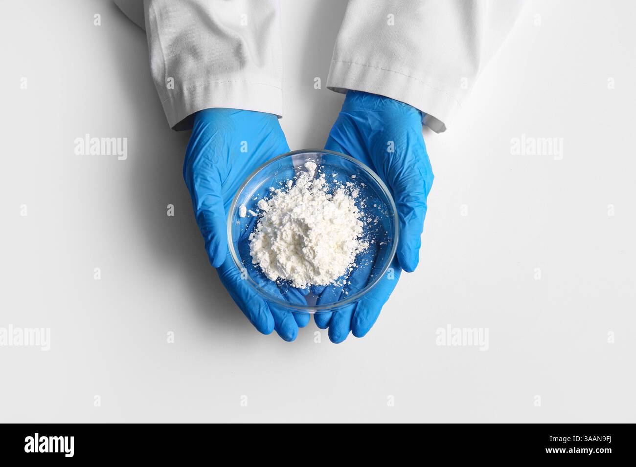 Female scientist's hands holding Petri dish with powder sample on white ...