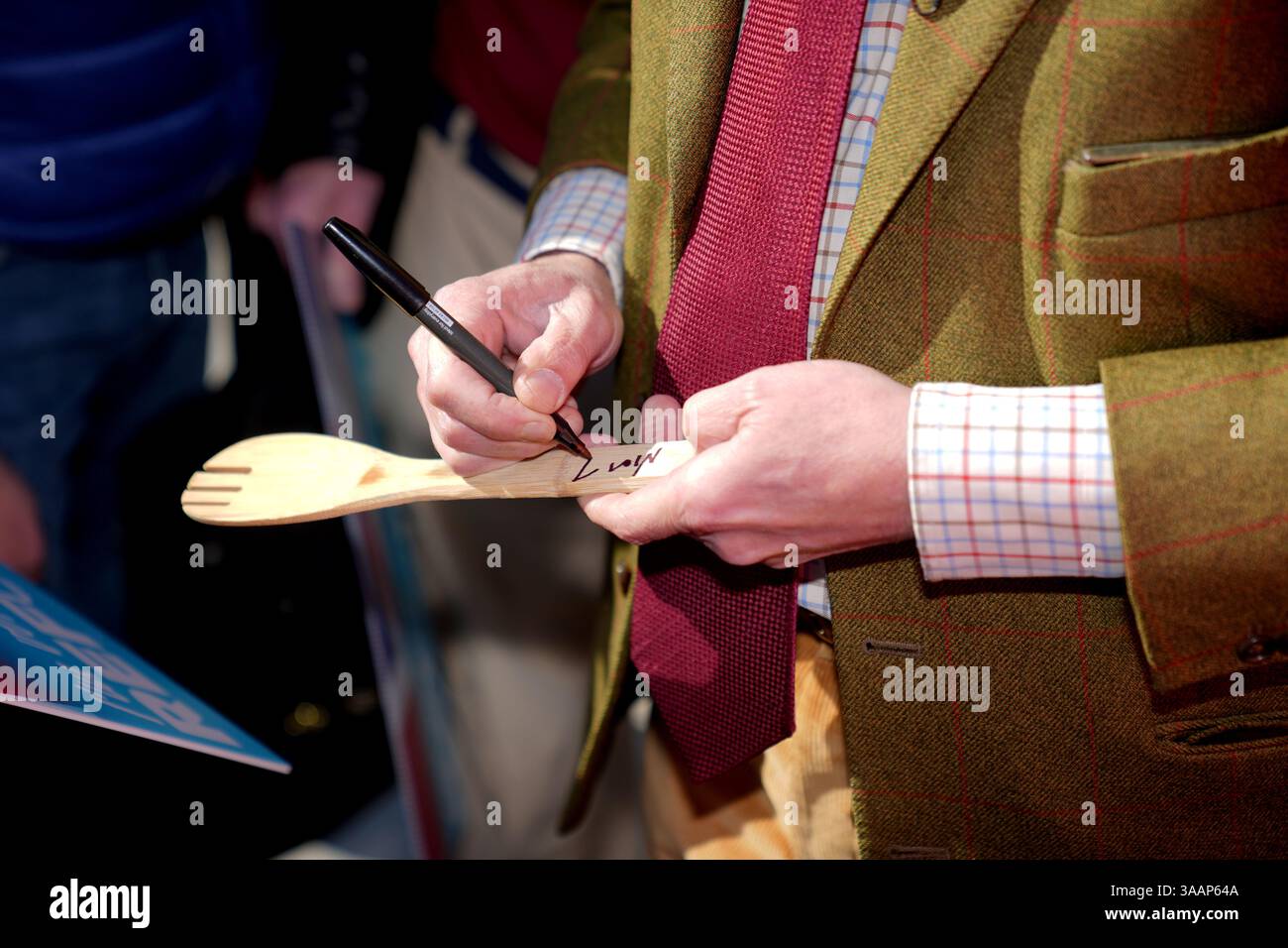 Reform UK leader Nigel Farage signs a wooden spoon during Reform UK's ...