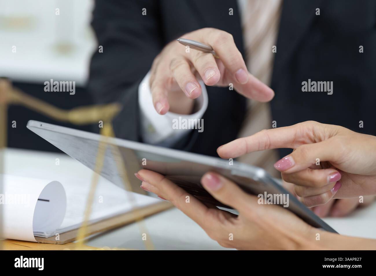 Legal Consultation and Digital Engagement. A lawyer guiding a client through documentation on a ...