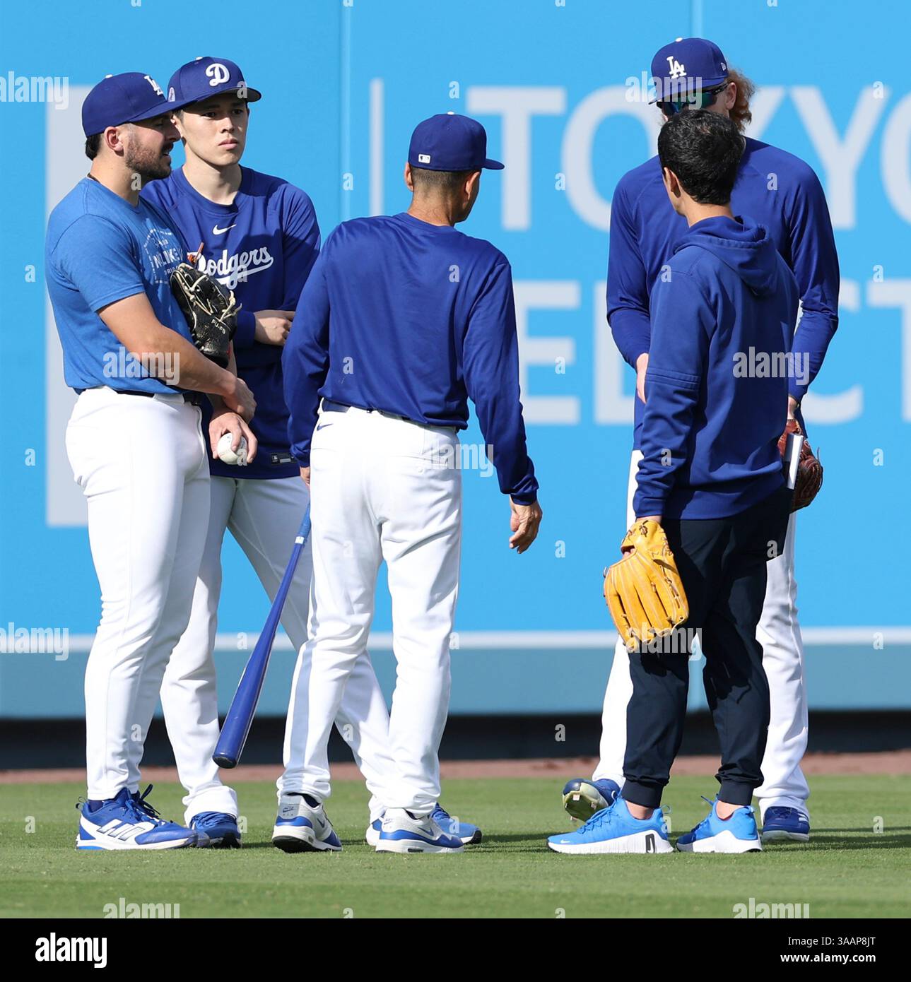 Los Angeles Dodgers pitcher Roki Suzuki (second from left) prepares for ...