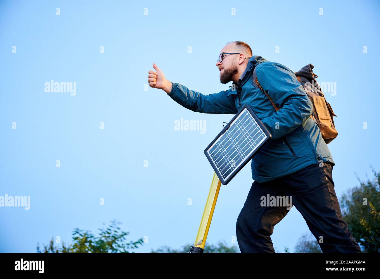 Man rides electric scooter while carrying solar panel, giving thumbs up ...
